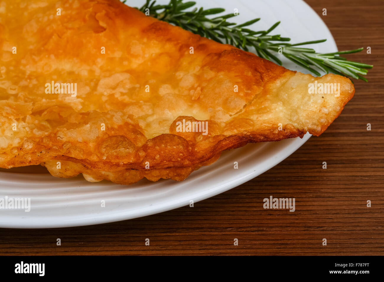 Traditional Meat Cheburek served rosemary on the wood background Stock ...