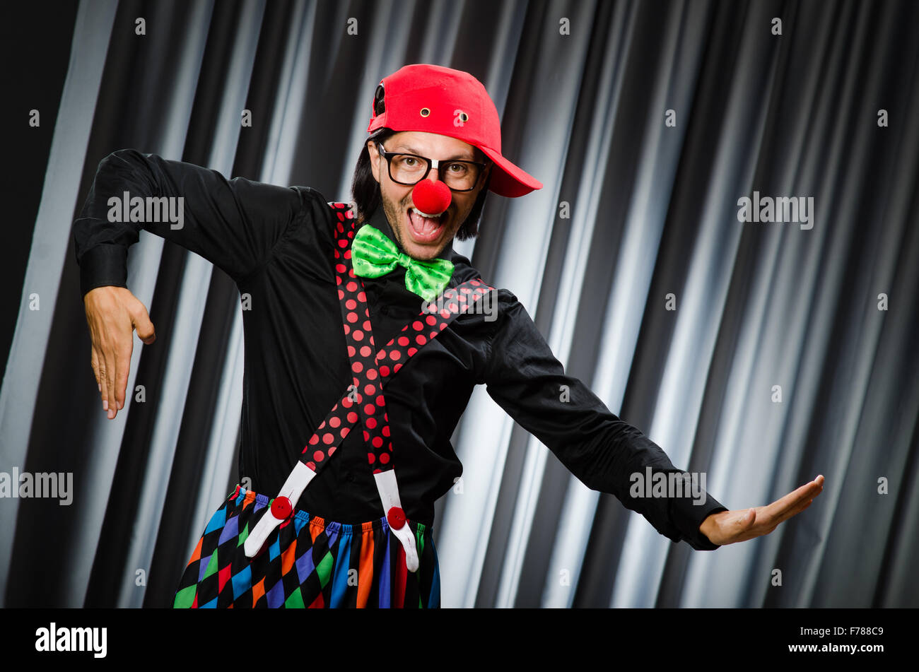 Funny clown in humorous concept against curtain Stock Photo - Alamy