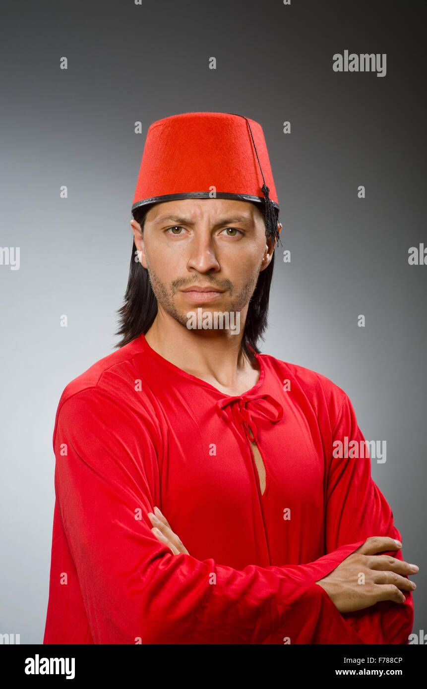 Funny man in red dress wearing fez hat Stock Photo - Alamy