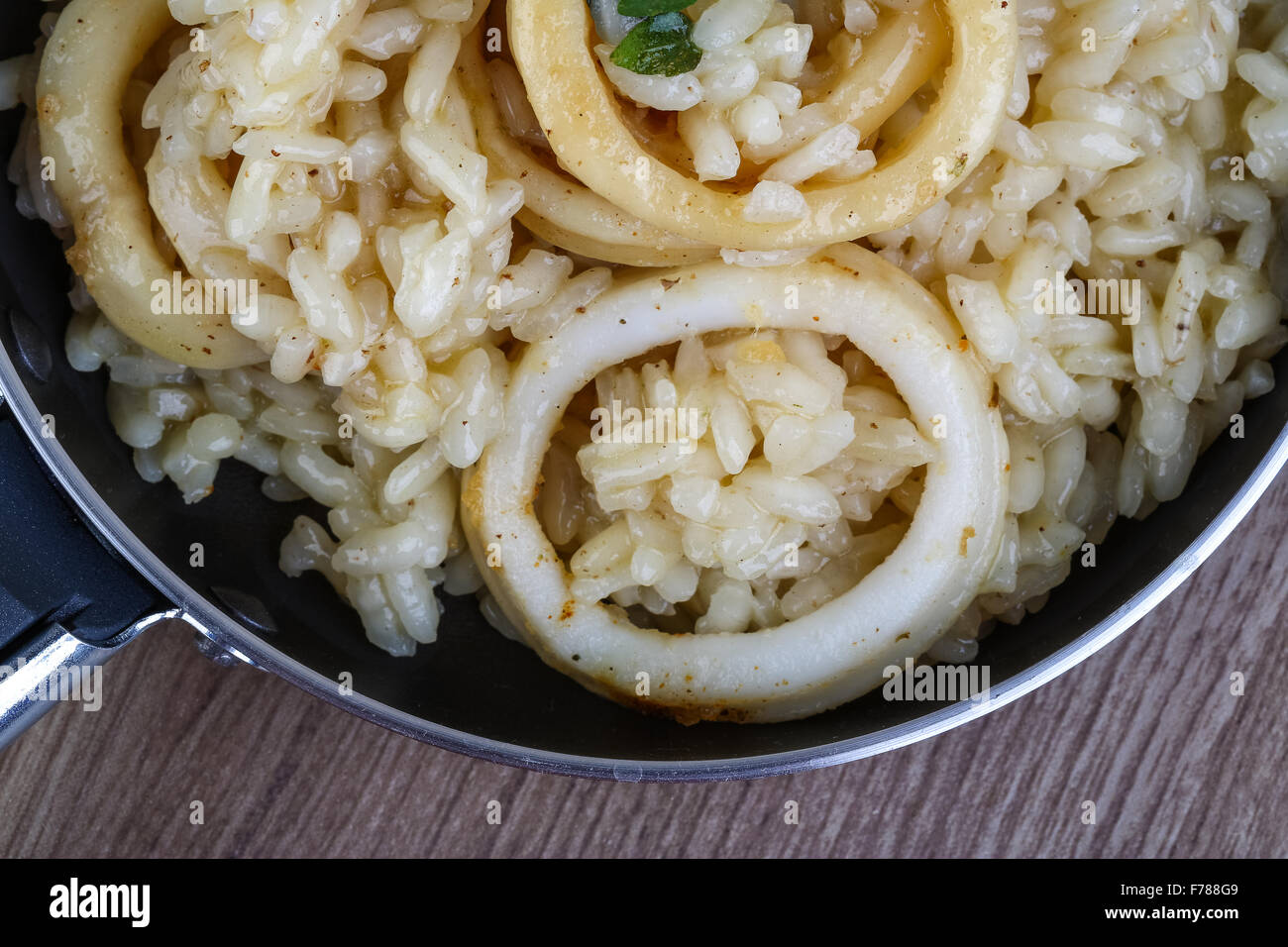 Italian famous cuisine - Squid risotto served basil leaves Stock Photo ...