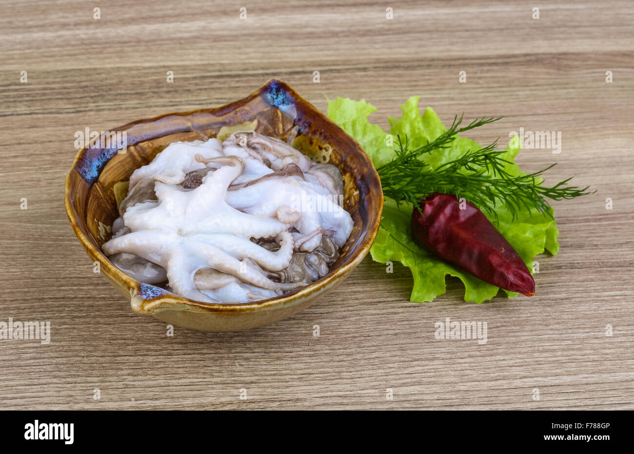 Raw baby octopus in the bowl ready for cooking Stock Photo - Alamy