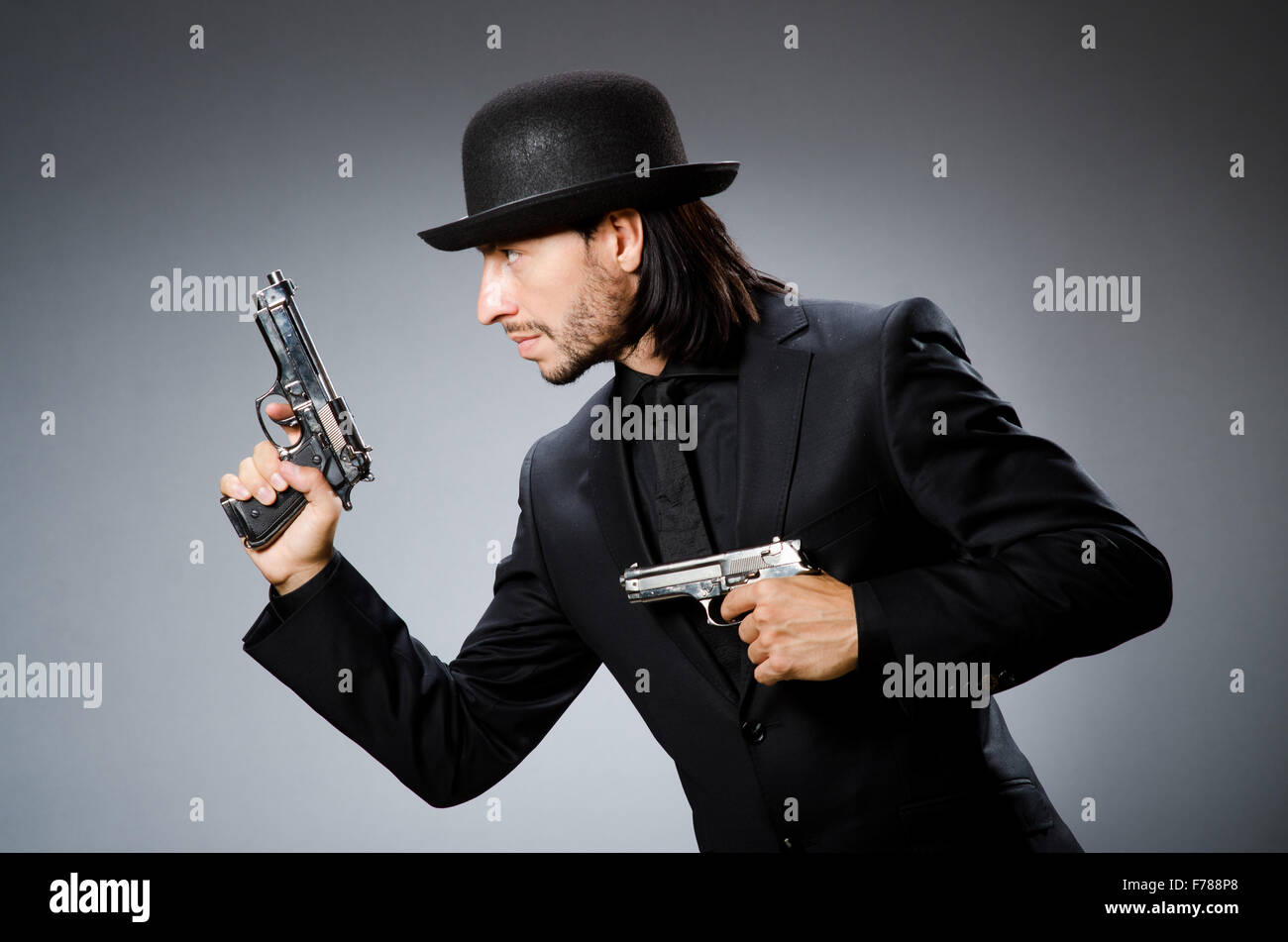 Man wearing vintage hat with gun Stock Photo - Alamy