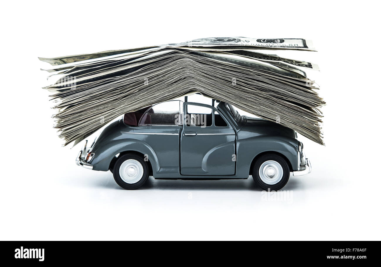 Side view on small decorative car model carries on itself a lot of cash ...