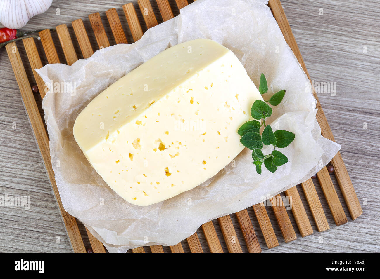 Part of round cheese on the wood background with herbs Stock Photo - Alamy