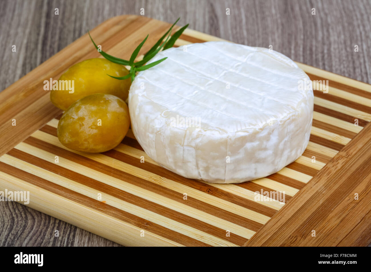 Round Brie cheese with yellow plums and estragon Stock Photo - Alamy