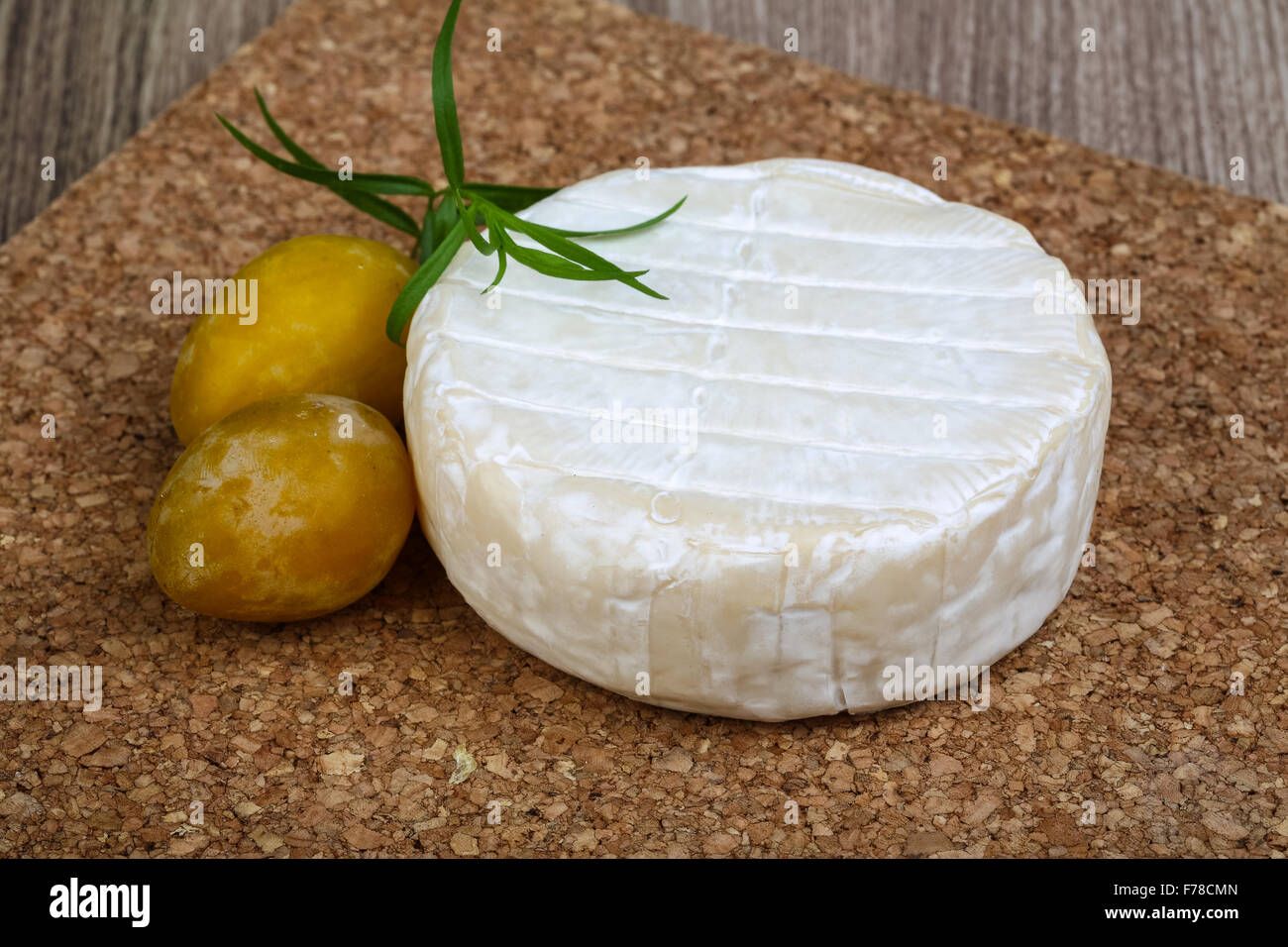 Round Brie cheese with yellow plums and estragon Stock Photo - Alamy