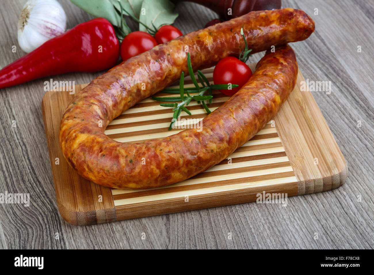 Sausage ring with rosemary and pepper on the wood background Stock ...