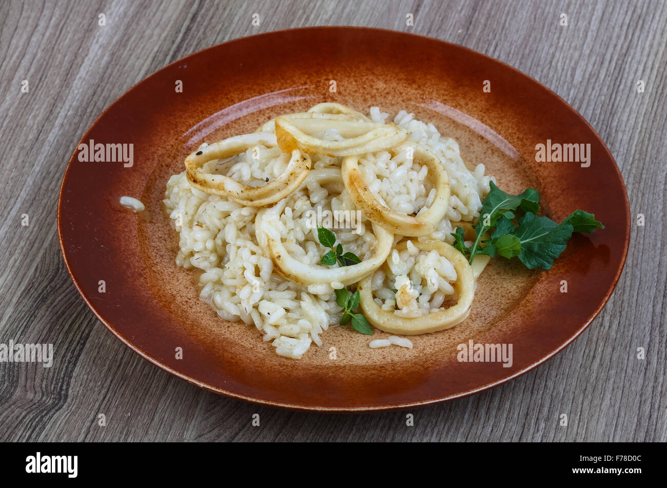 Italian famous cuisine - Squid risotto served basil leaves Stock Photo ...