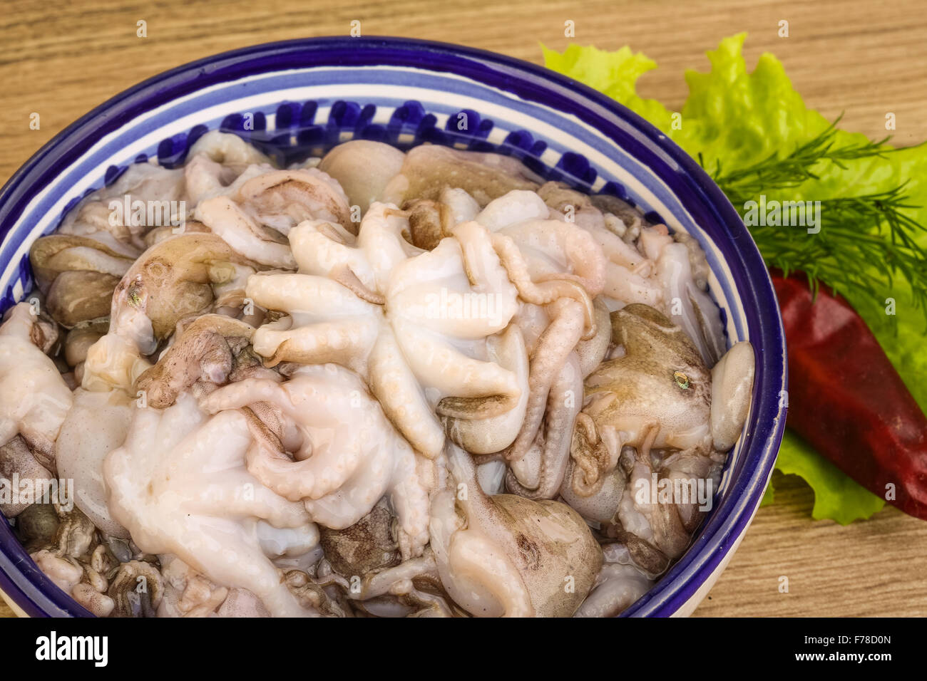 Raw baby octopus in the bowl ready for cooking Stock Photo - Alamy