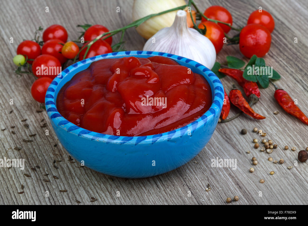 Bright Tomato ketchup with herbs and spices on the wood background ...