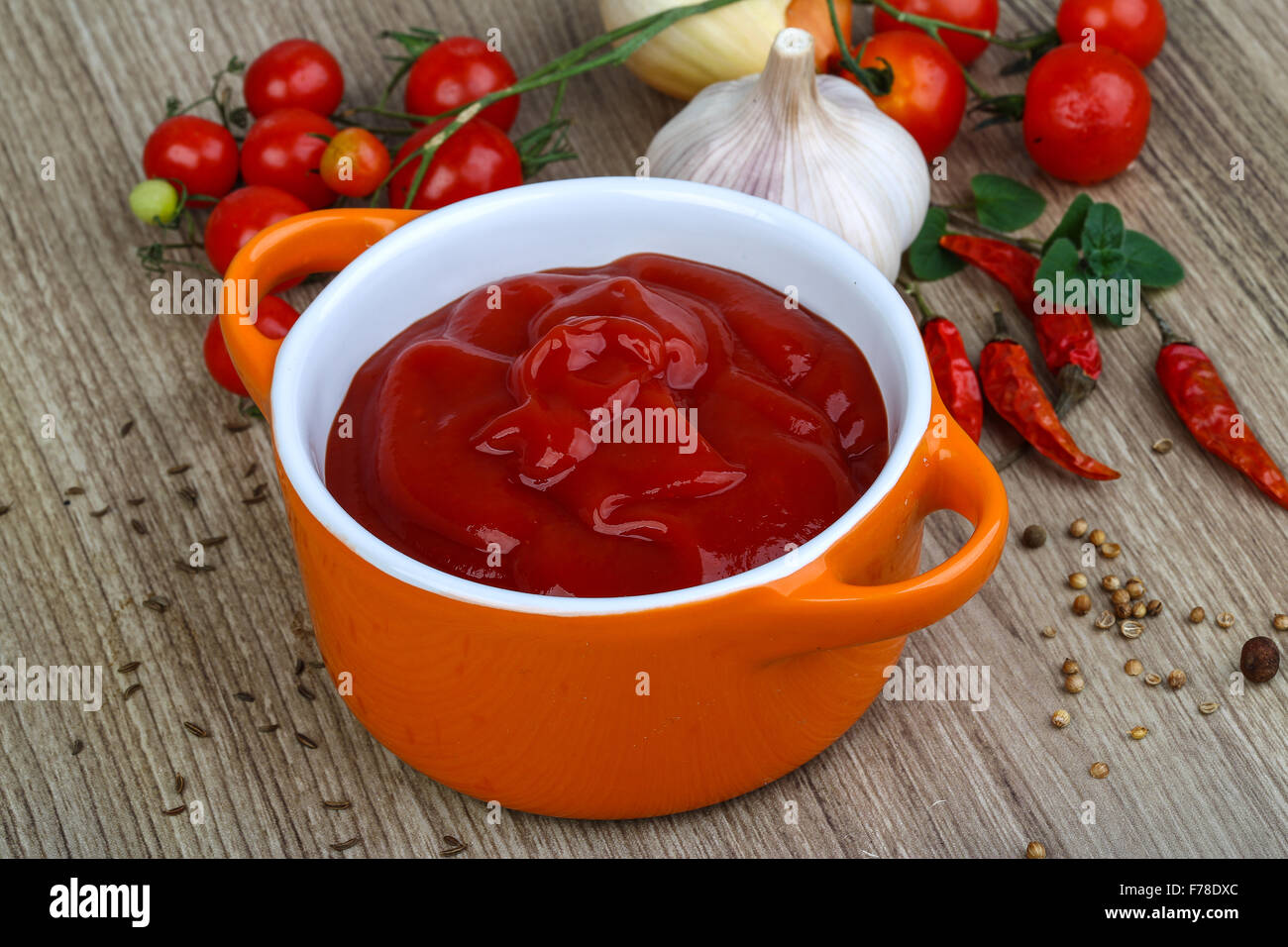 Bright Tomato ketchup with herbs and spices on the wood background ...