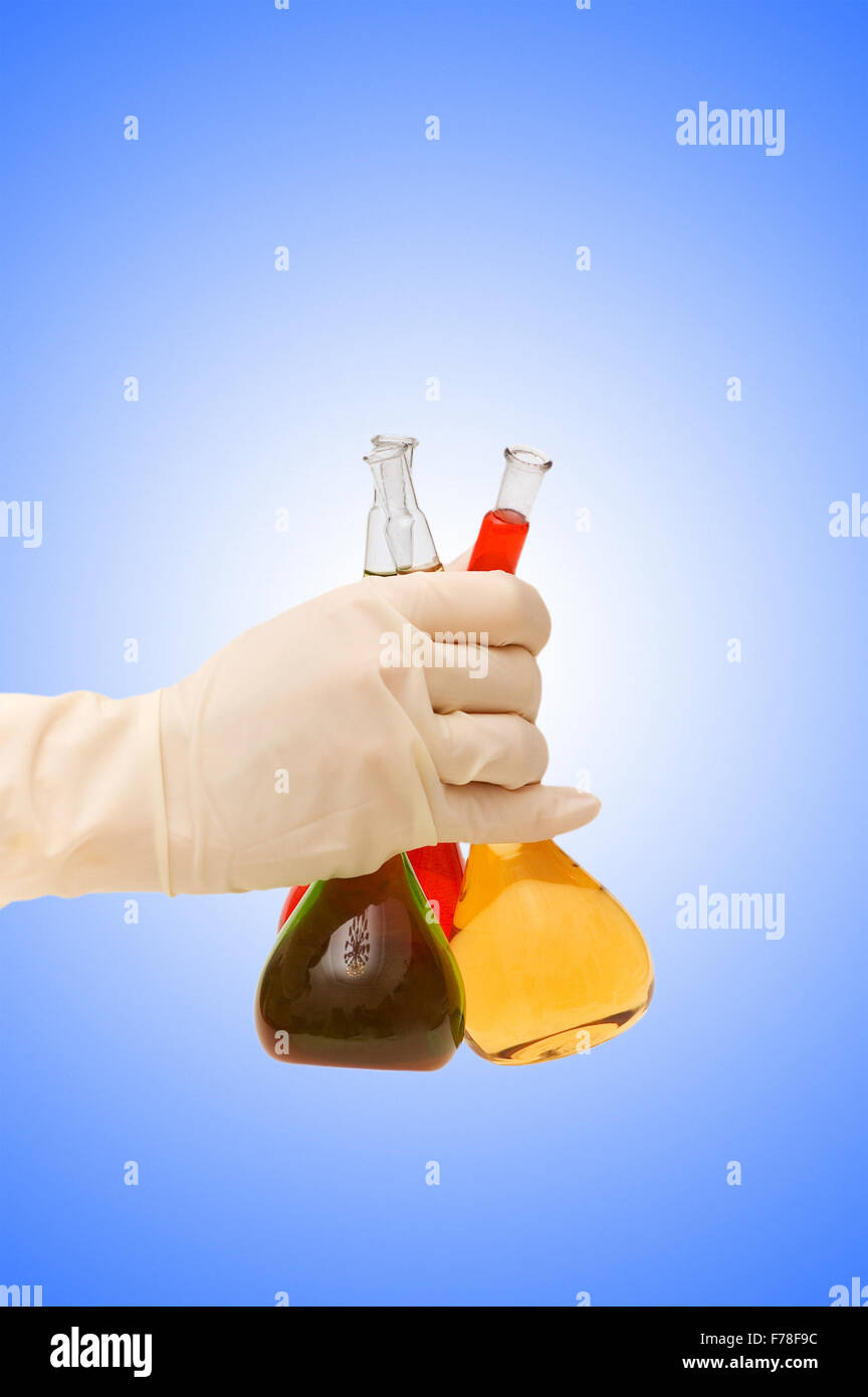 Hand with chemical solutions on gradient Stock Photo - Alamy