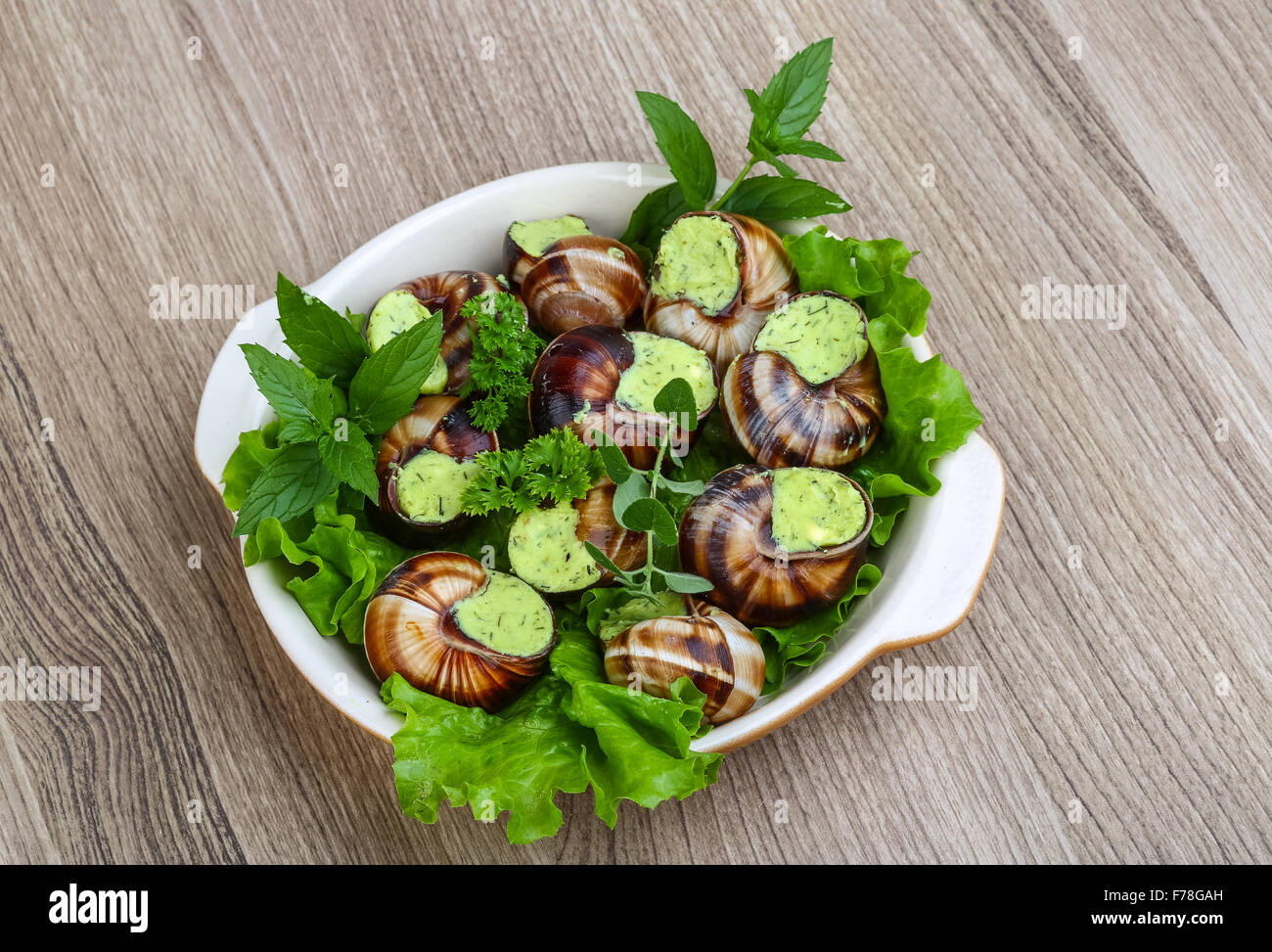 French cuisine - Escargot with butter, parsley and salat leaves Stock ...