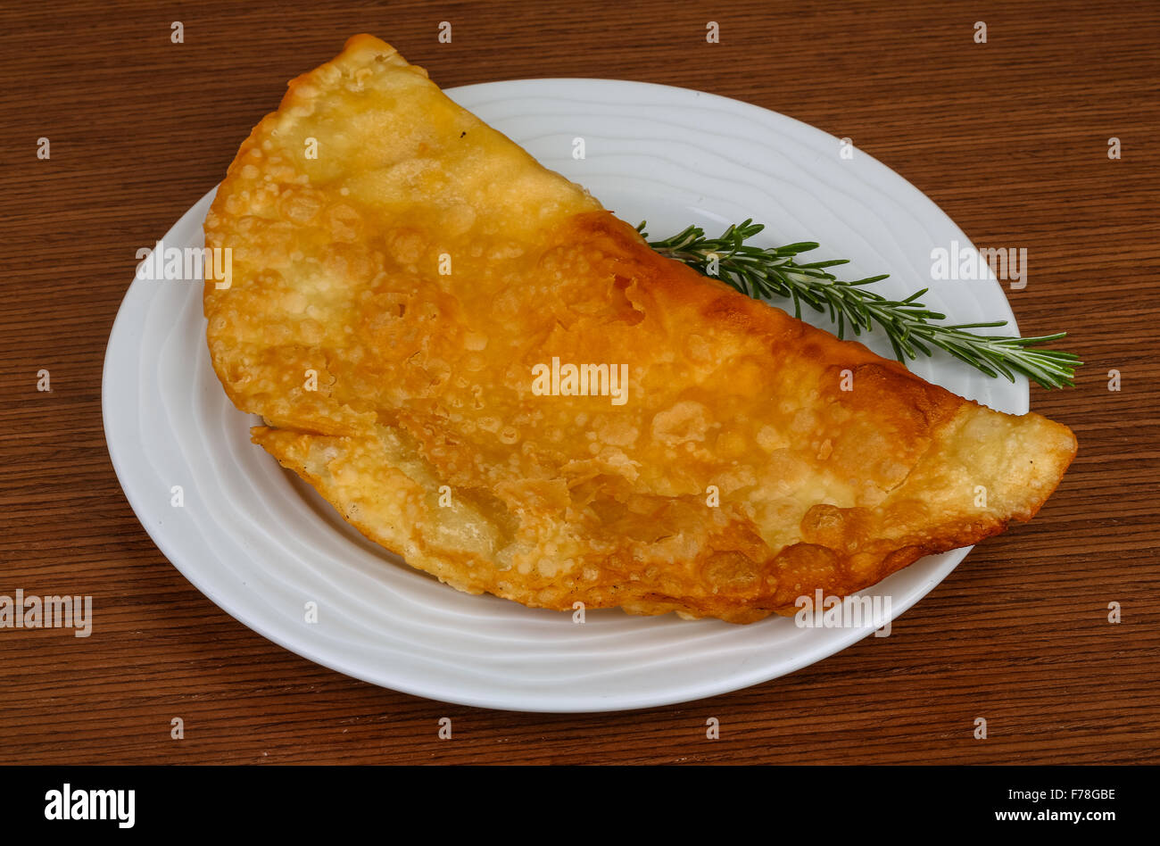 Traditional Meat Cheburek served rosemary on the wood background Stock ...