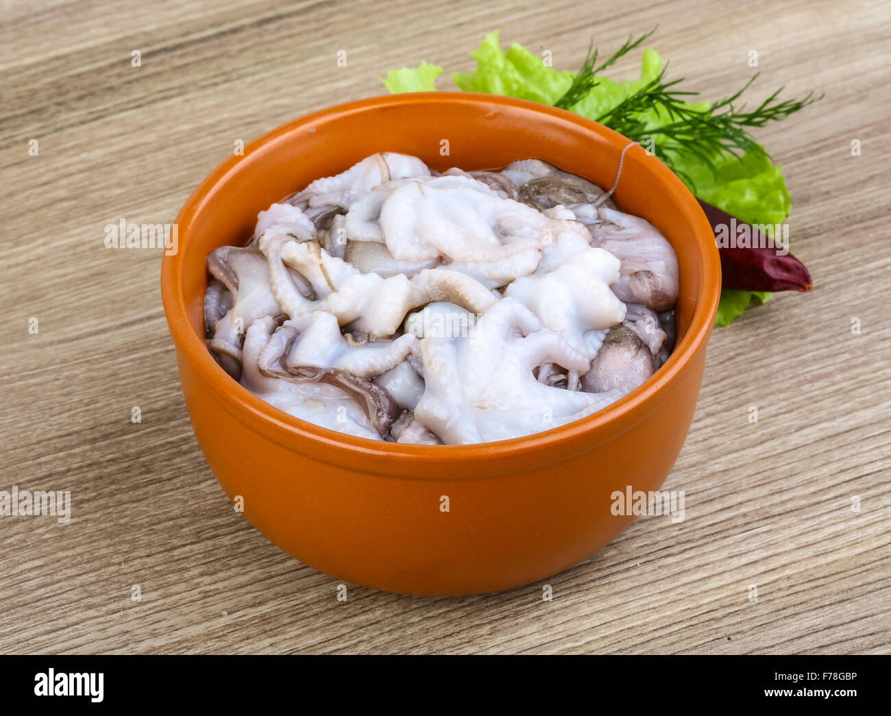 Raw baby octopus in the bowl ready for cooking Stock Photo - Alamy