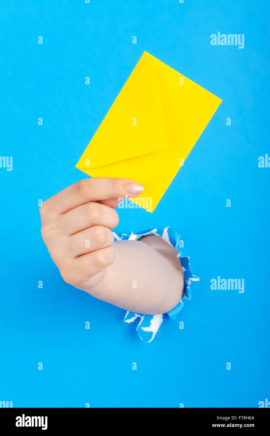Hand holding paper envelope from hole Stock Photo - Alamy