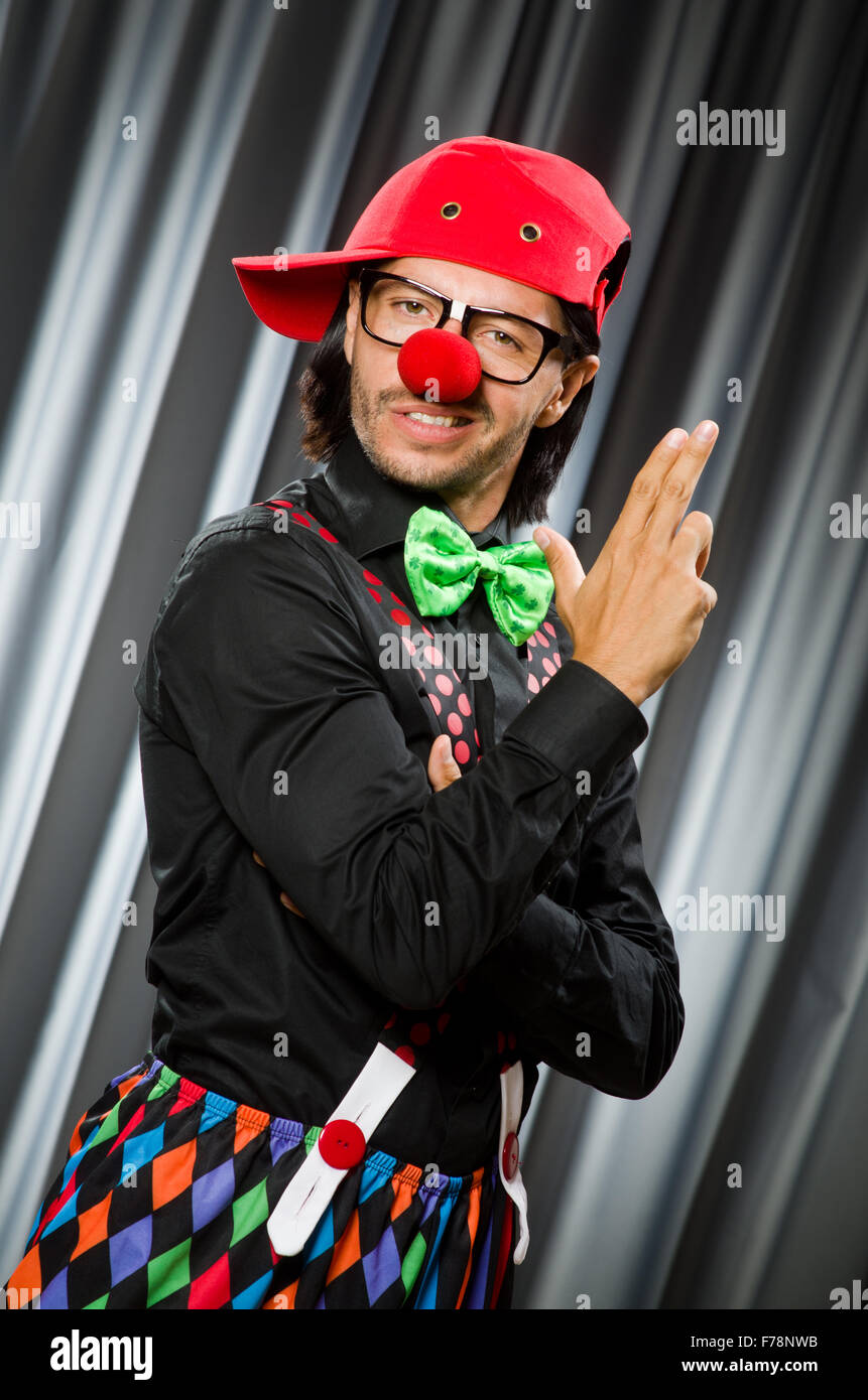 Funny clown in humorous concept against curtain Stock Photo - Alamy