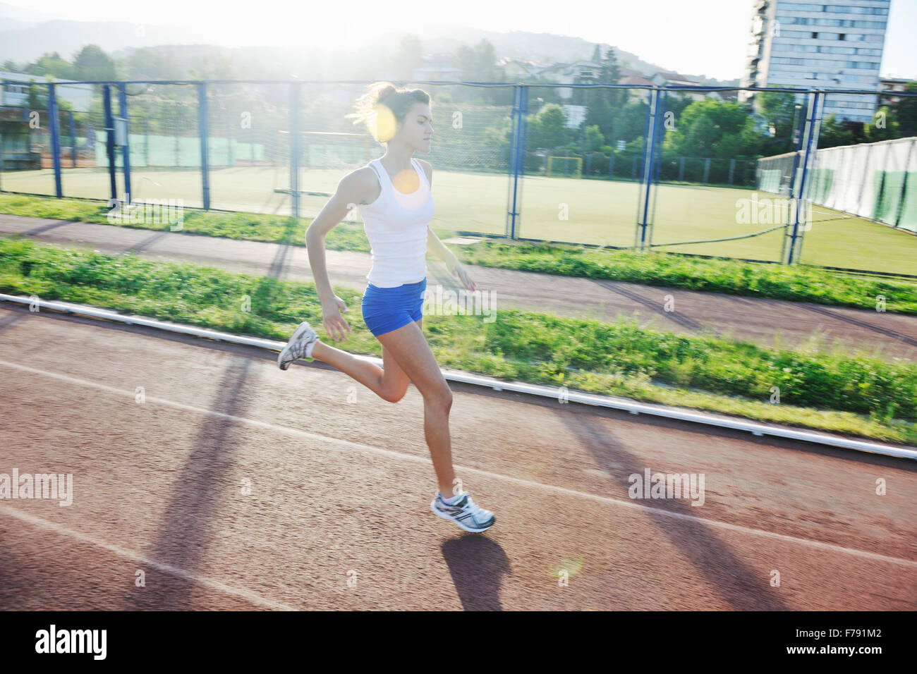 beautiful young woman exercise jogging and runing on athletic track on ...