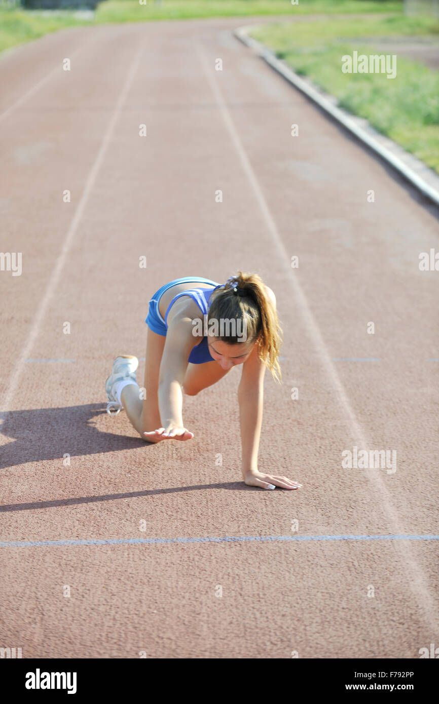 young woman finaly passing finis line at athletics running race track ...