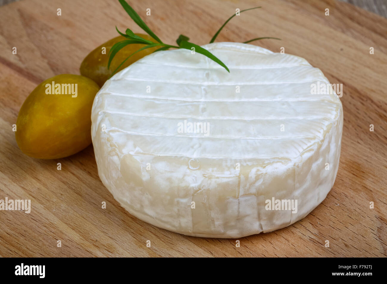 Round Brie cheese with yellow plums and estragon Stock Photo - Alamy