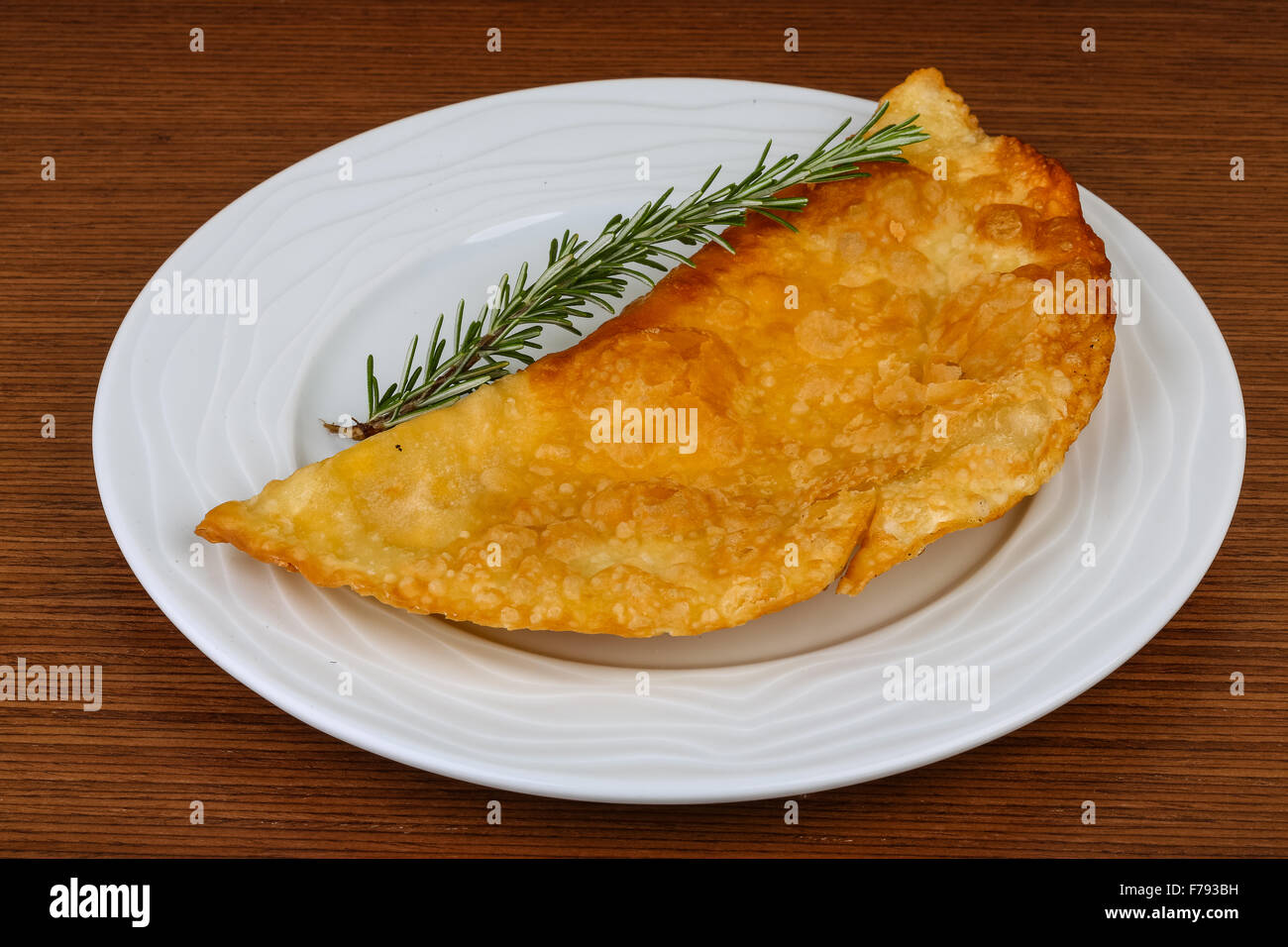 Traditional Meat Cheburek served rosemary on the wood background Stock ...