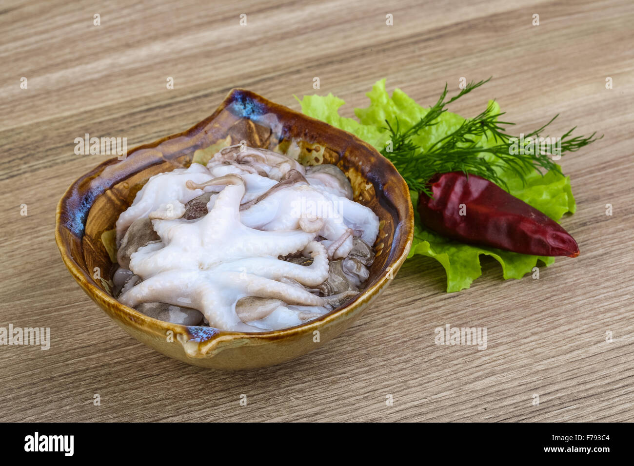 Raw baby octopus in the bowl ready for cooking Stock Photo - Alamy