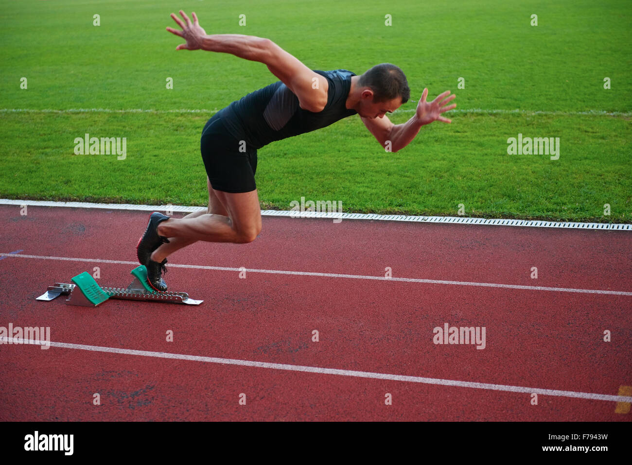 Sprinter leaving starting blocks on the running track. Explosive start ...