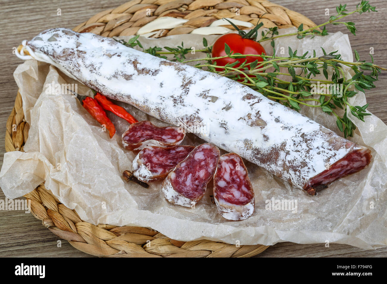 Traditional Spanish sausages- fuet with thyme leaves on the wood ...