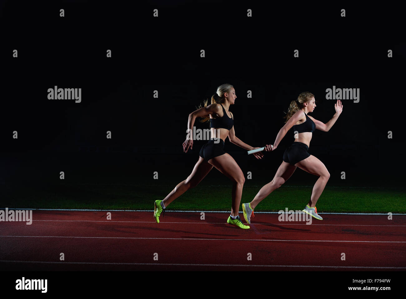 woman athletic runners passing baton in relay race Stock Photo - Alamy