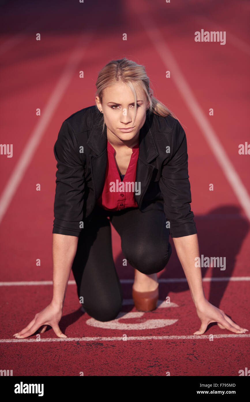 business woman in start position ready to run and sprint on athletics ...