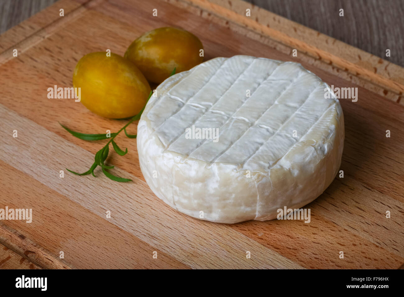 Round Brie cheese with yellow plums and estragon Stock Photo - Alamy