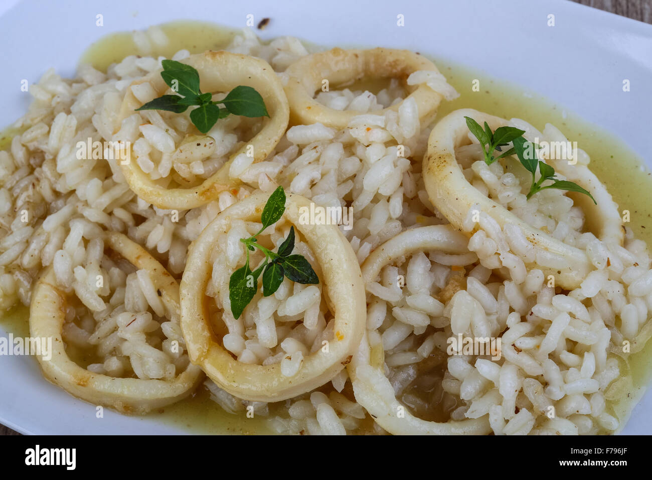 Italian famous cuisine - Squid risotto served basil leaves Stock Photo ...