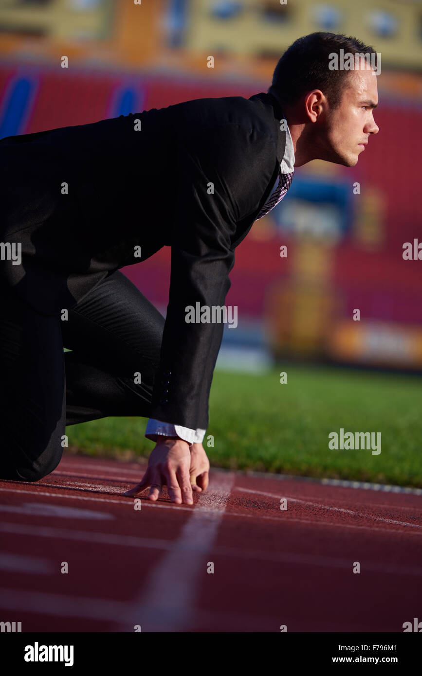 business man in start position ready to run and sprint on athletics ...