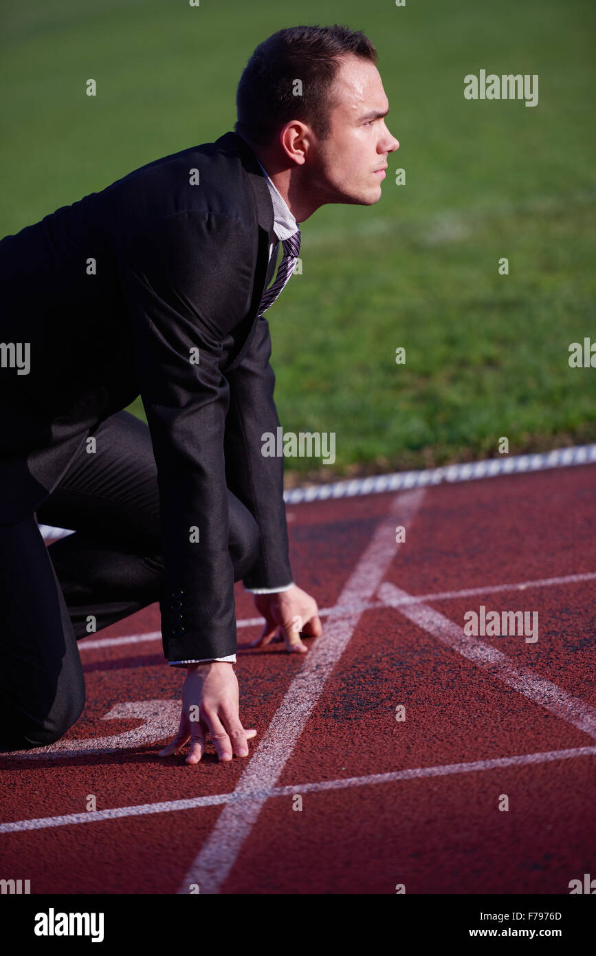 business man in start position ready to run and sprint on athletics ...