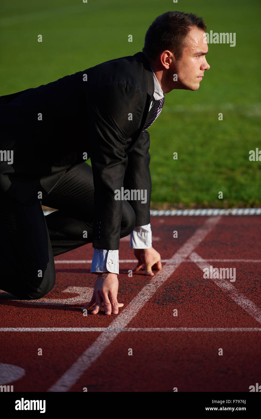 business man in start position ready to run and sprint on athletics ...