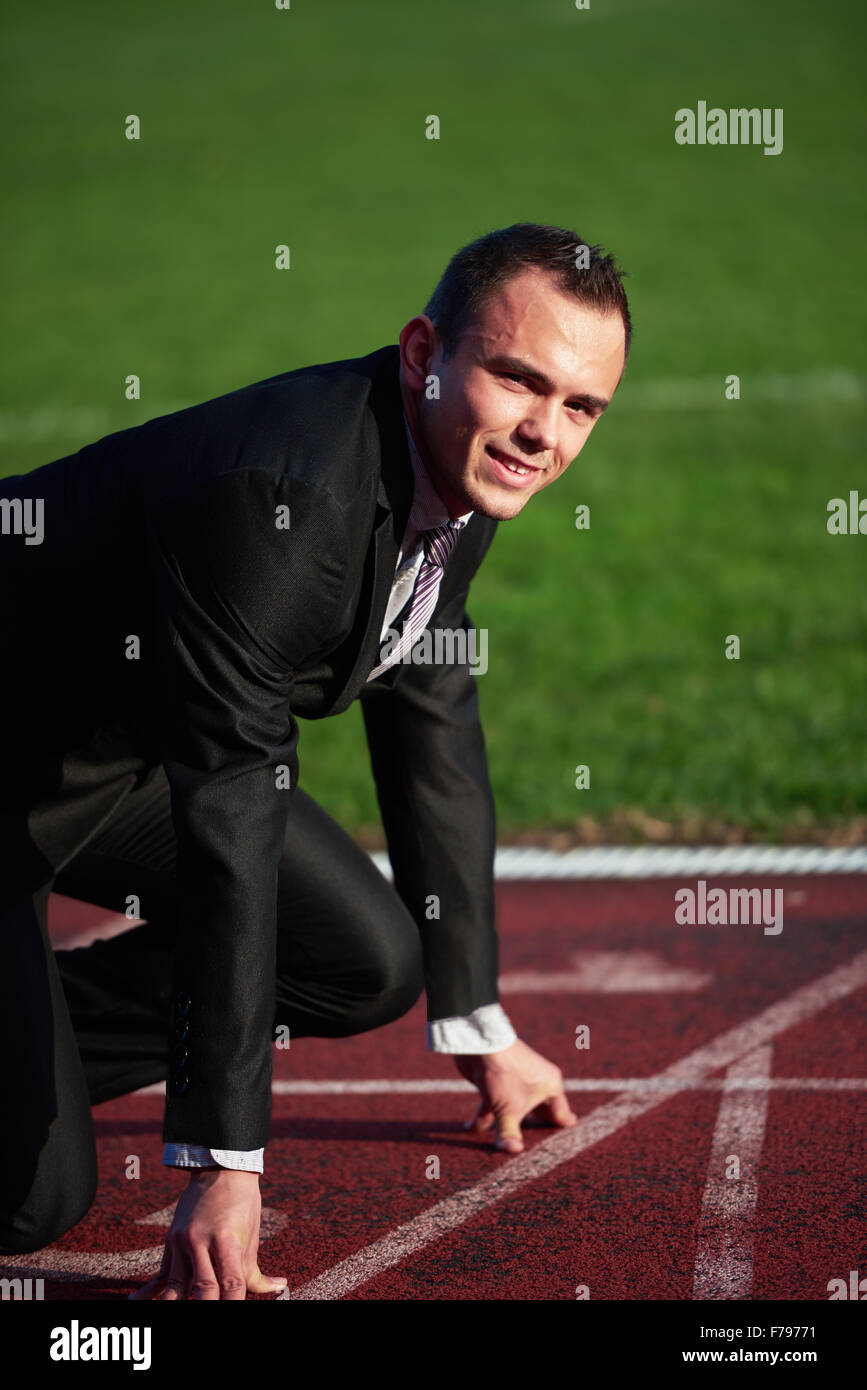 business man in start position ready to run and sprint on athletics ...