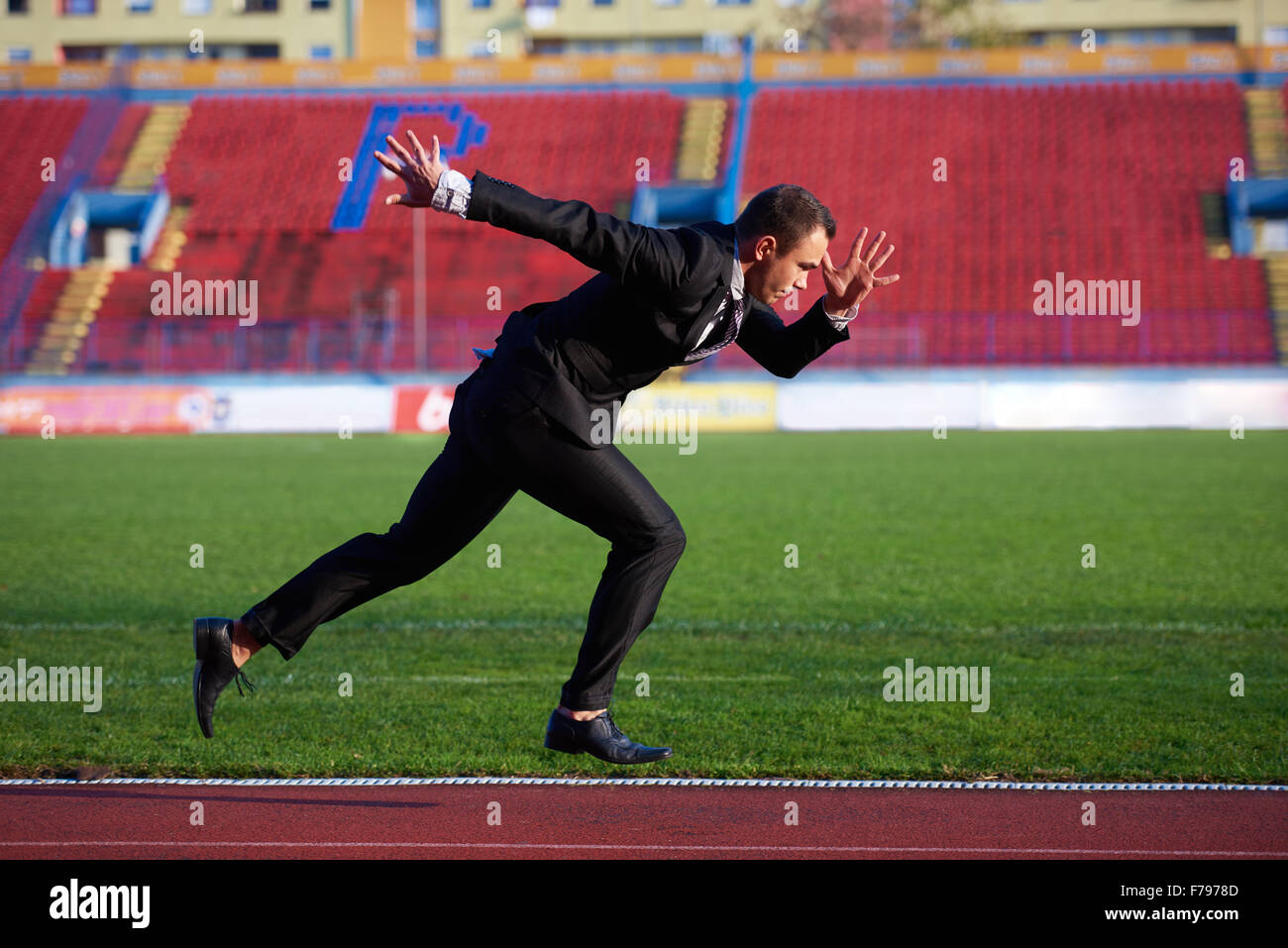 business man in start position ready to run and sprint on athletics ...