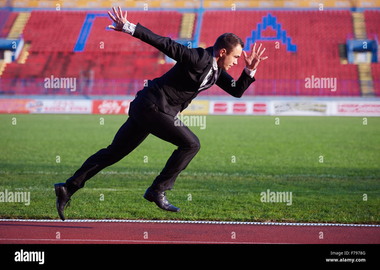 business man in start position ready to run and sprint on athletics ...
