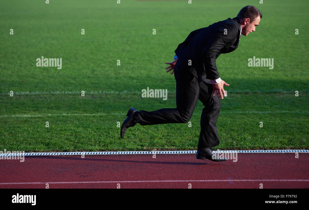 business man in start position ready to run and sprint on athletics ...