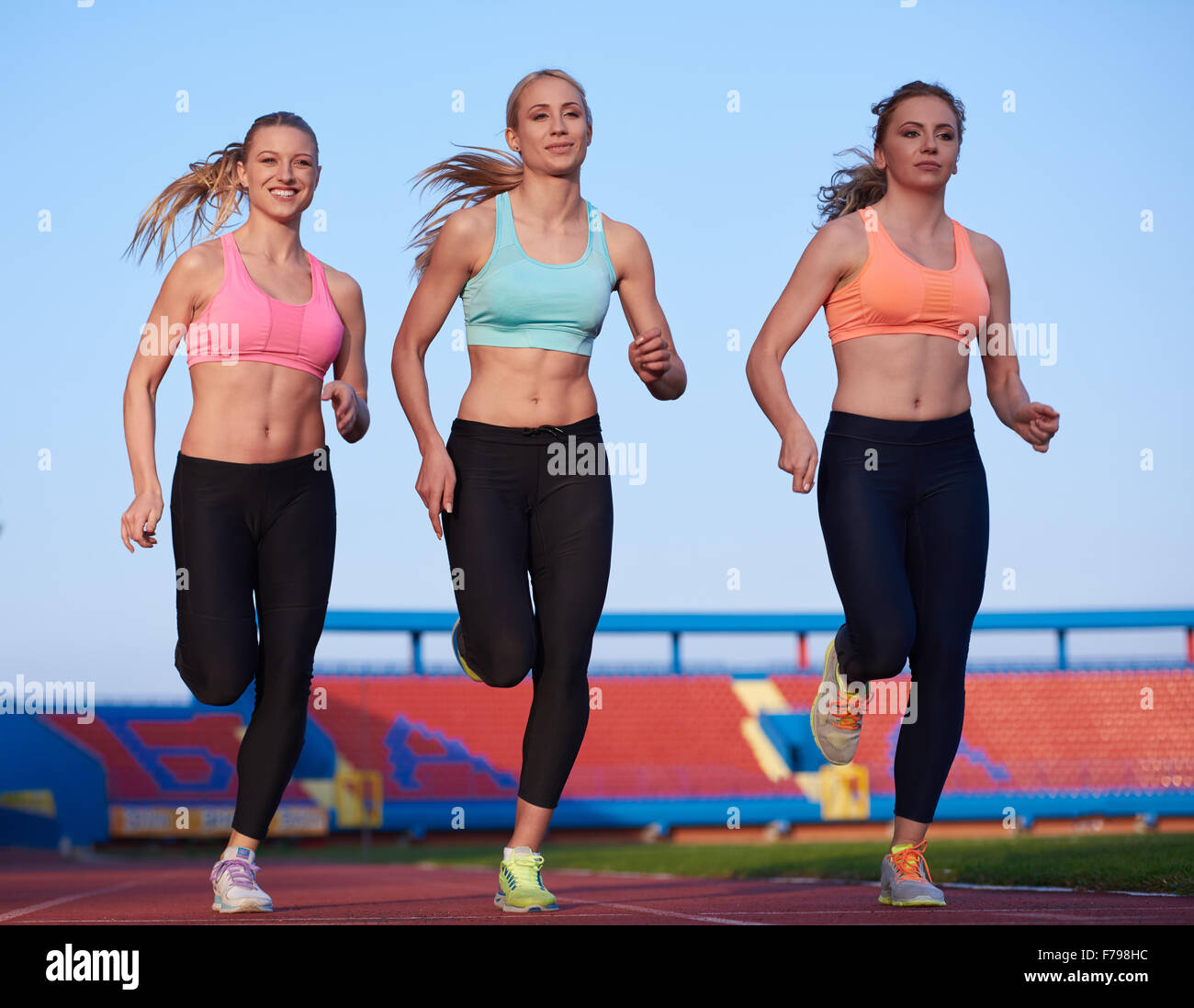 athlete woman group running on athletics race track on soccer stadium ...