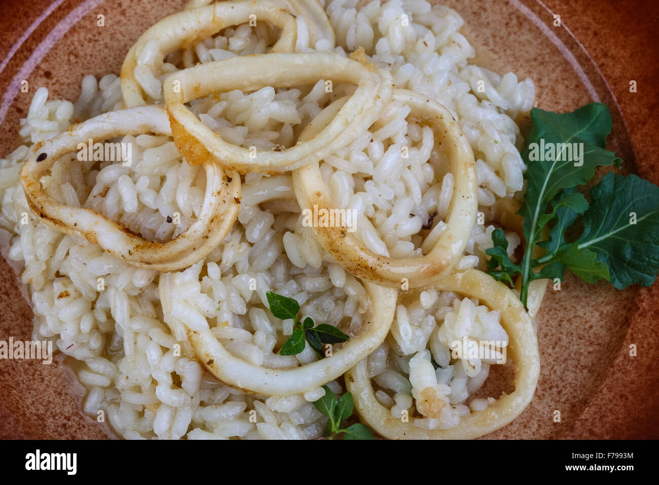 Italian famous cuisine - Squid risotto served basil leaves Stock Photo ...