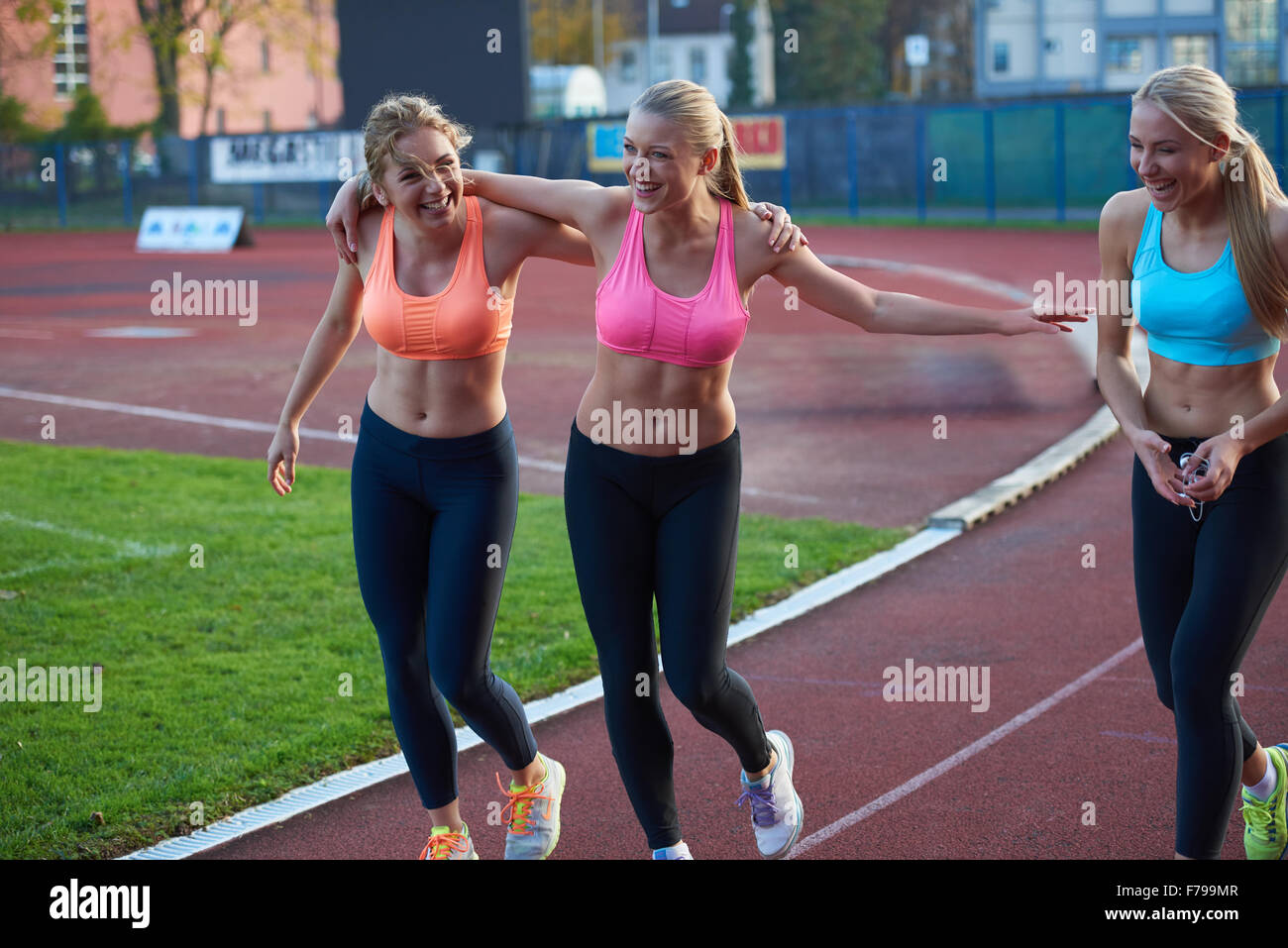 athlete woman group running on athletics race track on soccer stadium ...