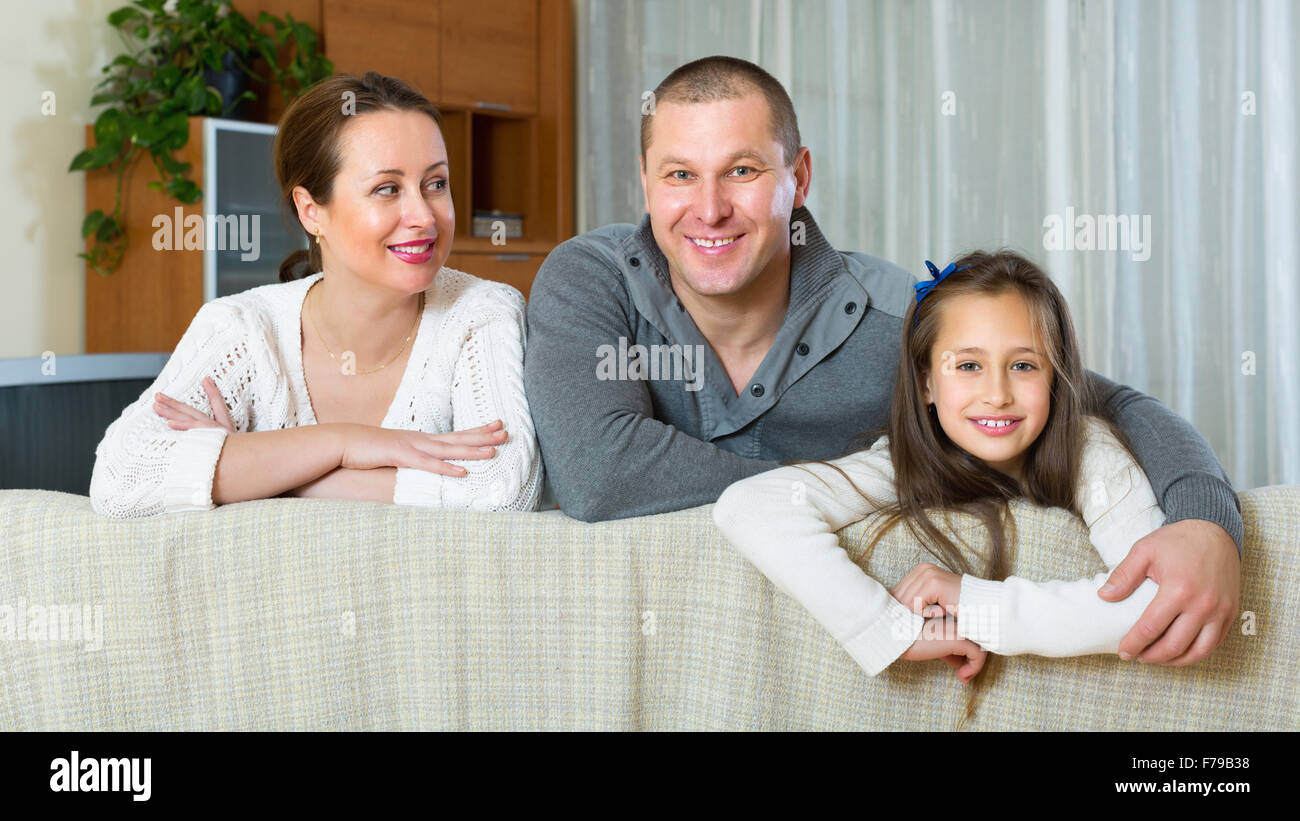 Smiling family of three in domestic interior Stock Photo - Alamy