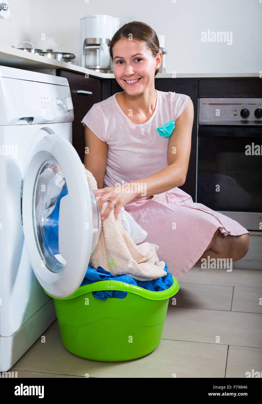 young woman doing laundry at home and smiling Stock Photo - Alamy