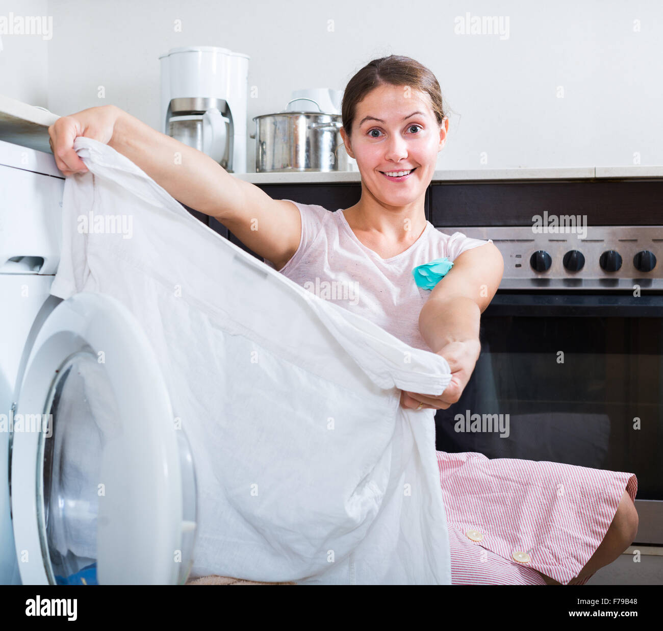 Positive young woman doing laundry at home and smiling Stock Photo - Alamy