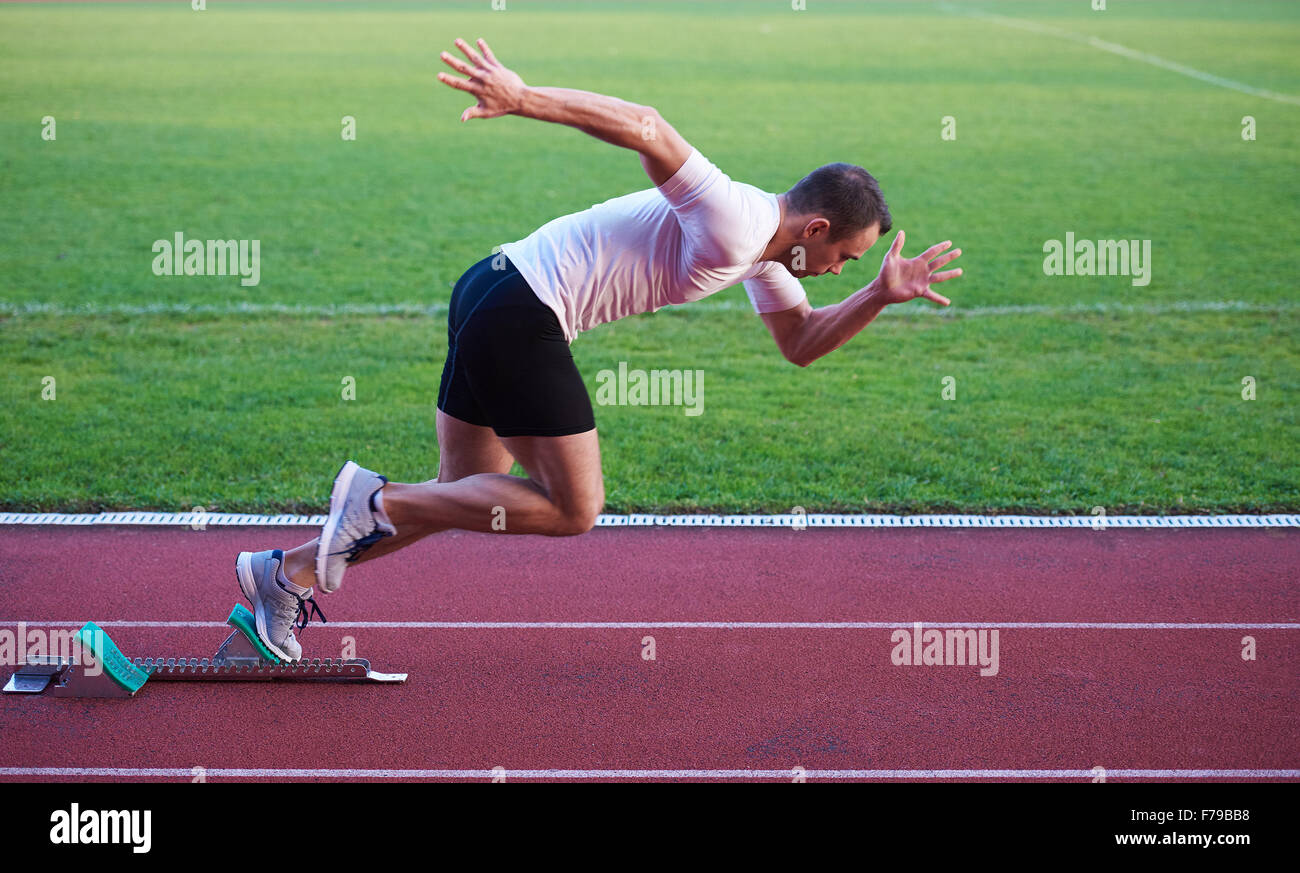 Sprinter leaving starting blocks on the running track. Explosive start ...