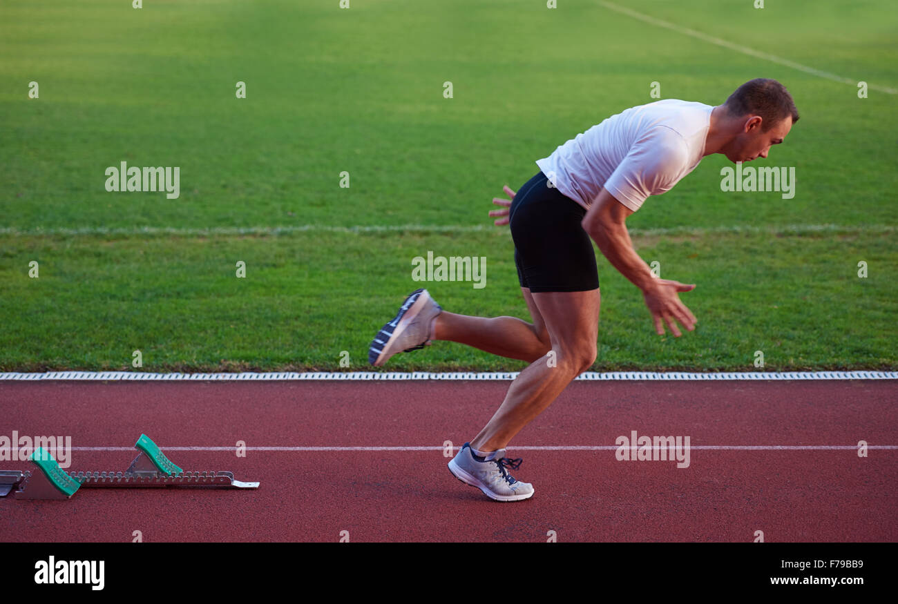 Sprinter leaving starting blocks on the running track. Explosive start ...