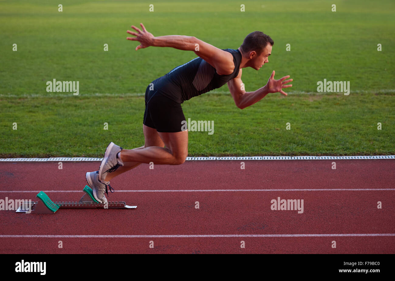 Sprinter leaving starting blocks on the running track. Explosive start ...
