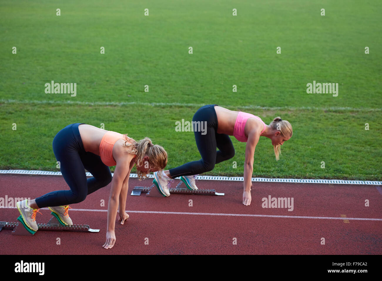 athlete woman group running on athletics race track on soccer stadium ...