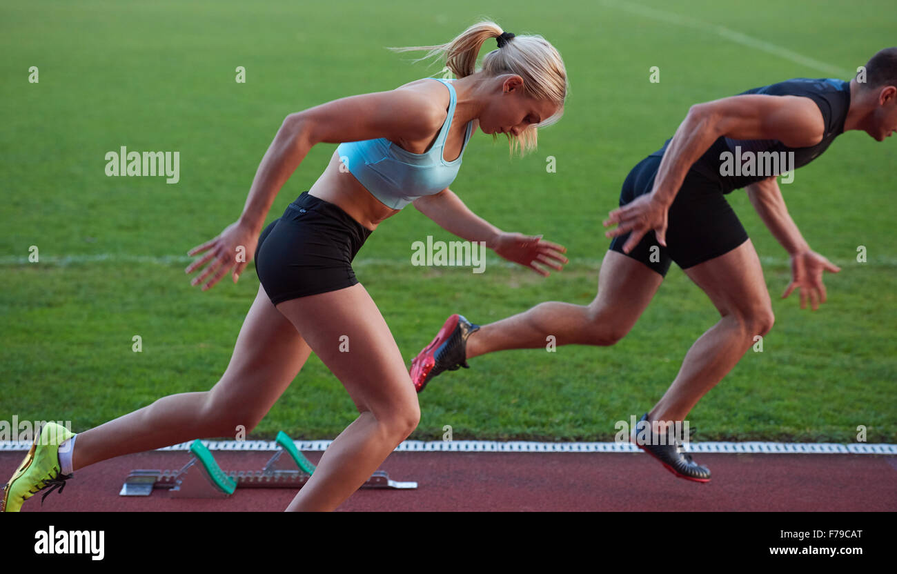 athlete woman group running on athletics race track on soccer stadium ...